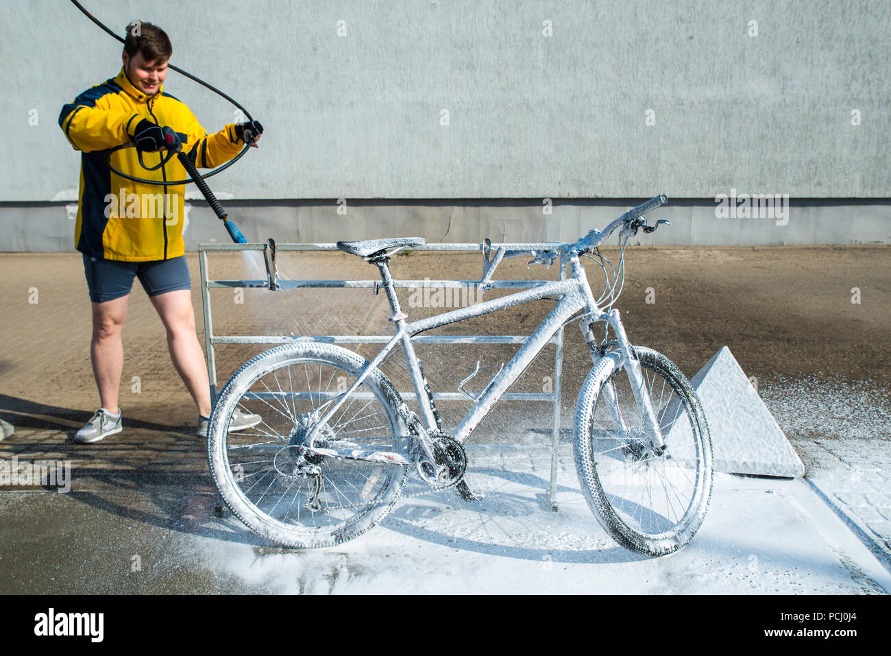 young man washing bicycle at carwash. lifestyle Stock Photo - Alamy
