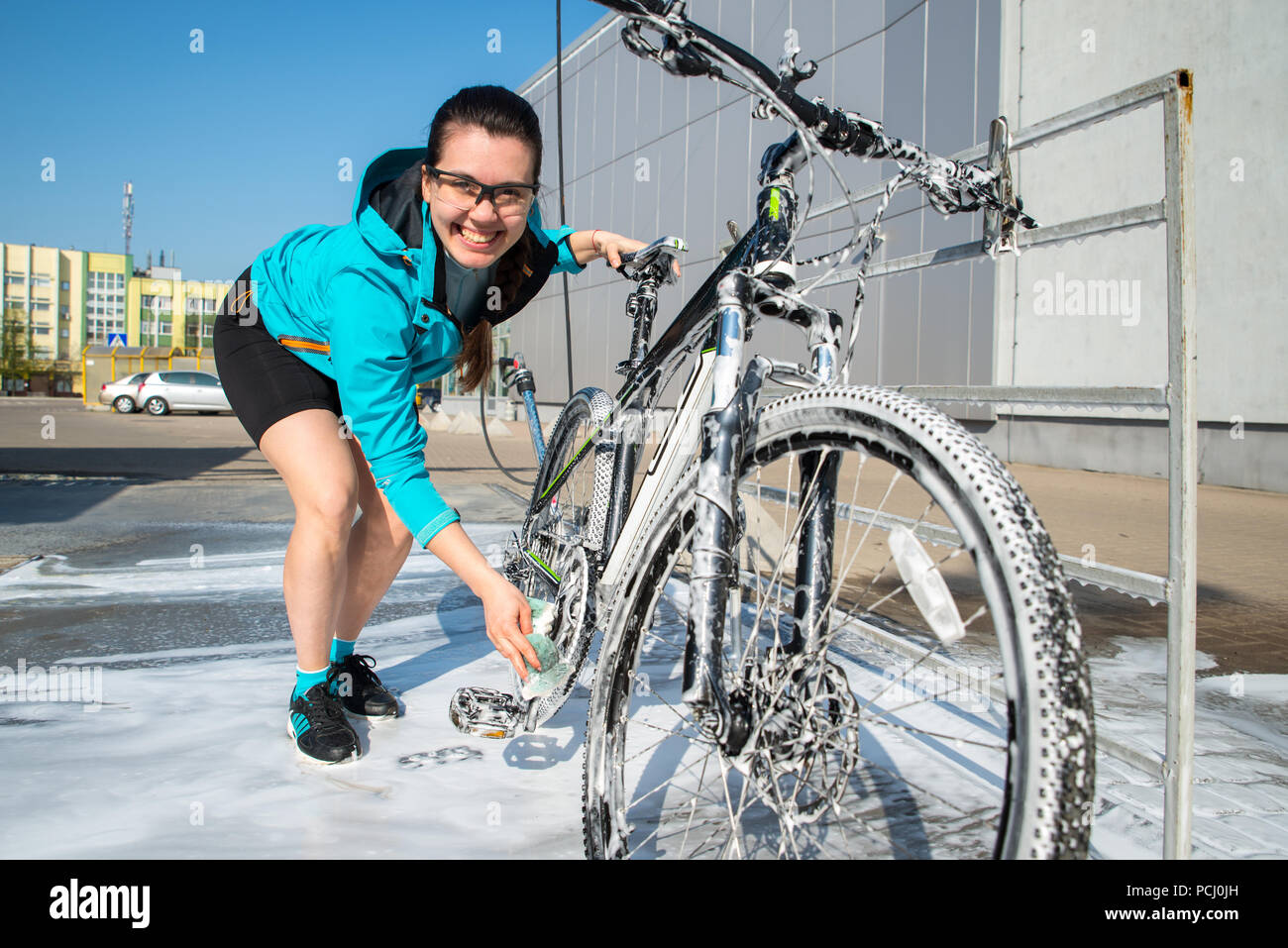 young sport woman washing bicycle at self-service car wash Stock Photo ...