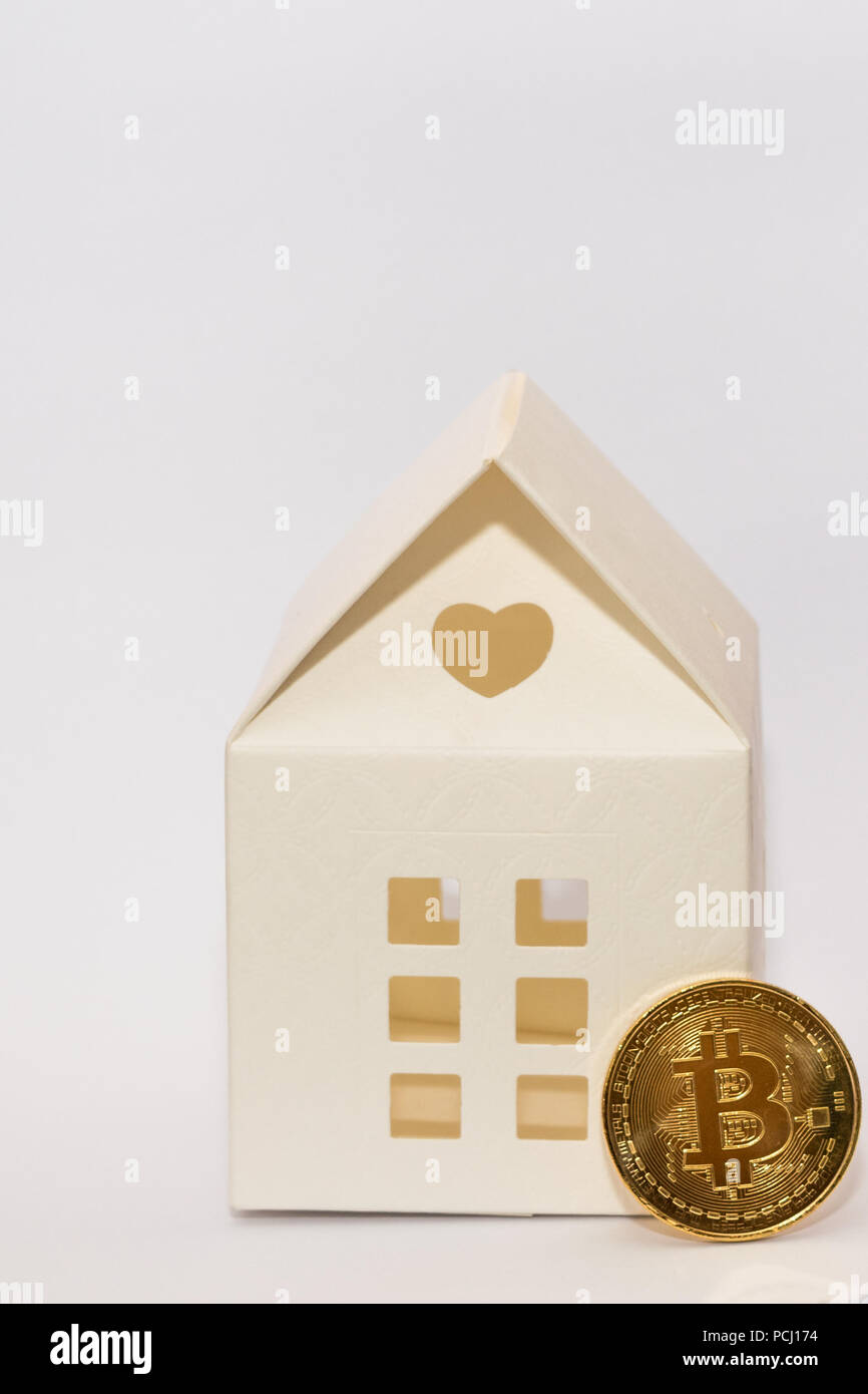 bitcoin coin and paper model house. conceptual image for paying a house ...