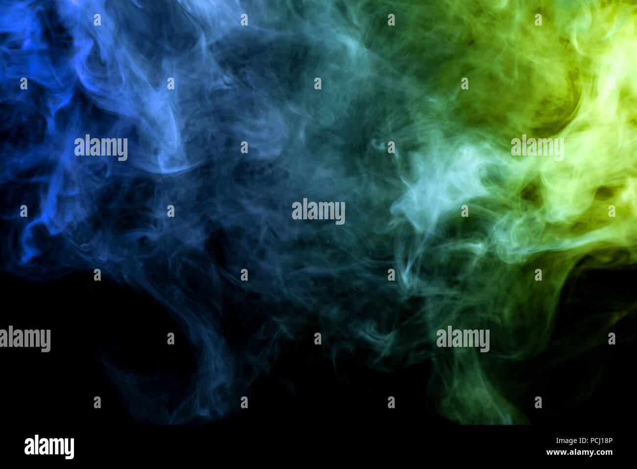 Dense multicolored smoke of blue and green colors on a black isolated ...