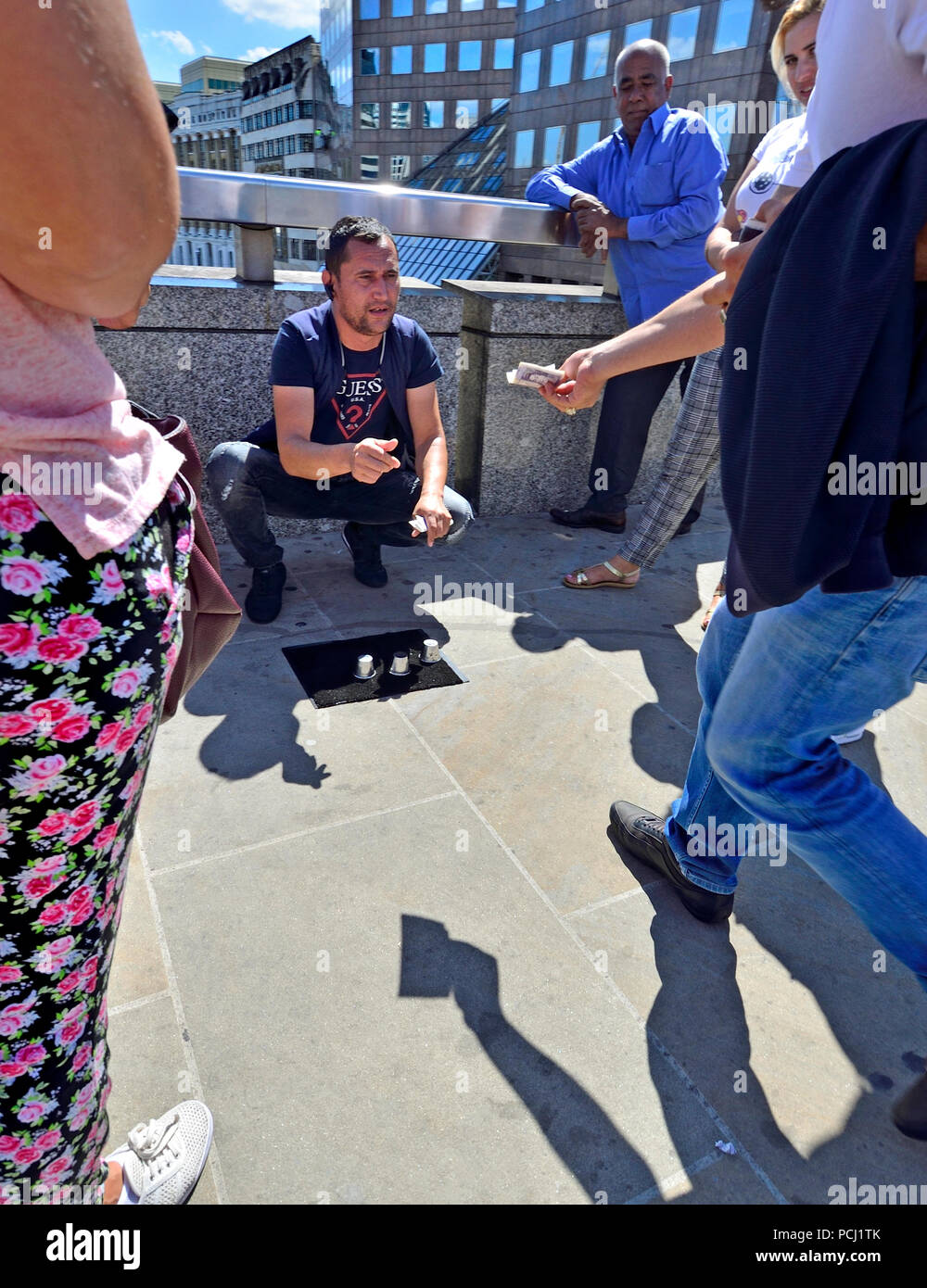 Man illegally performing the cups and ball trick / three shell game, on ...