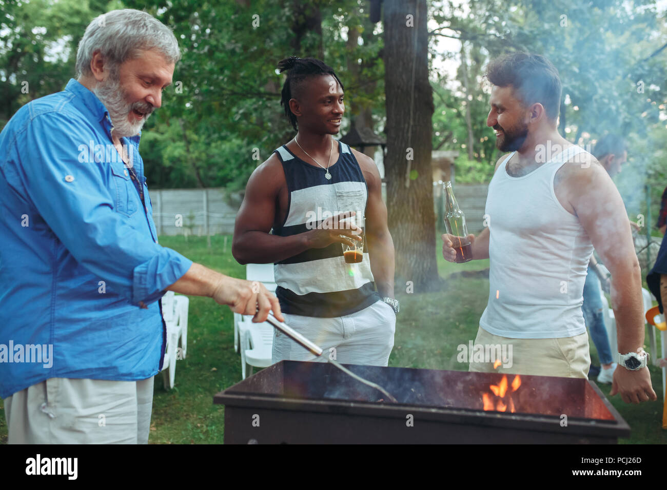 Group of friends making barbecue in the backyard. concept about good ...