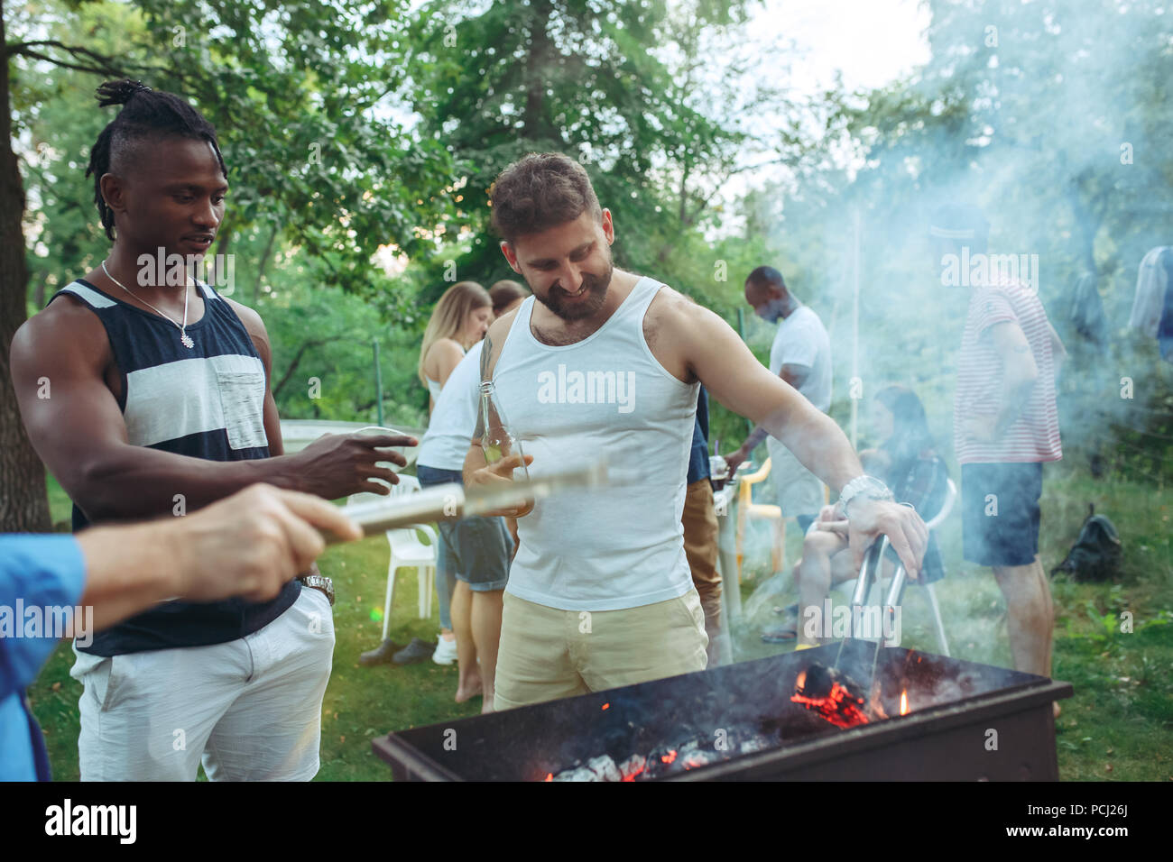 Group of friends making barbecue in the backyard. concept about good ...