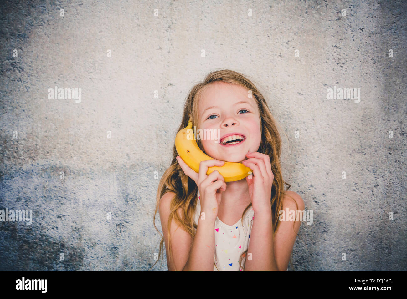 blond, Pretty girl is doing phone call with a banana Stock Photo - Alamy