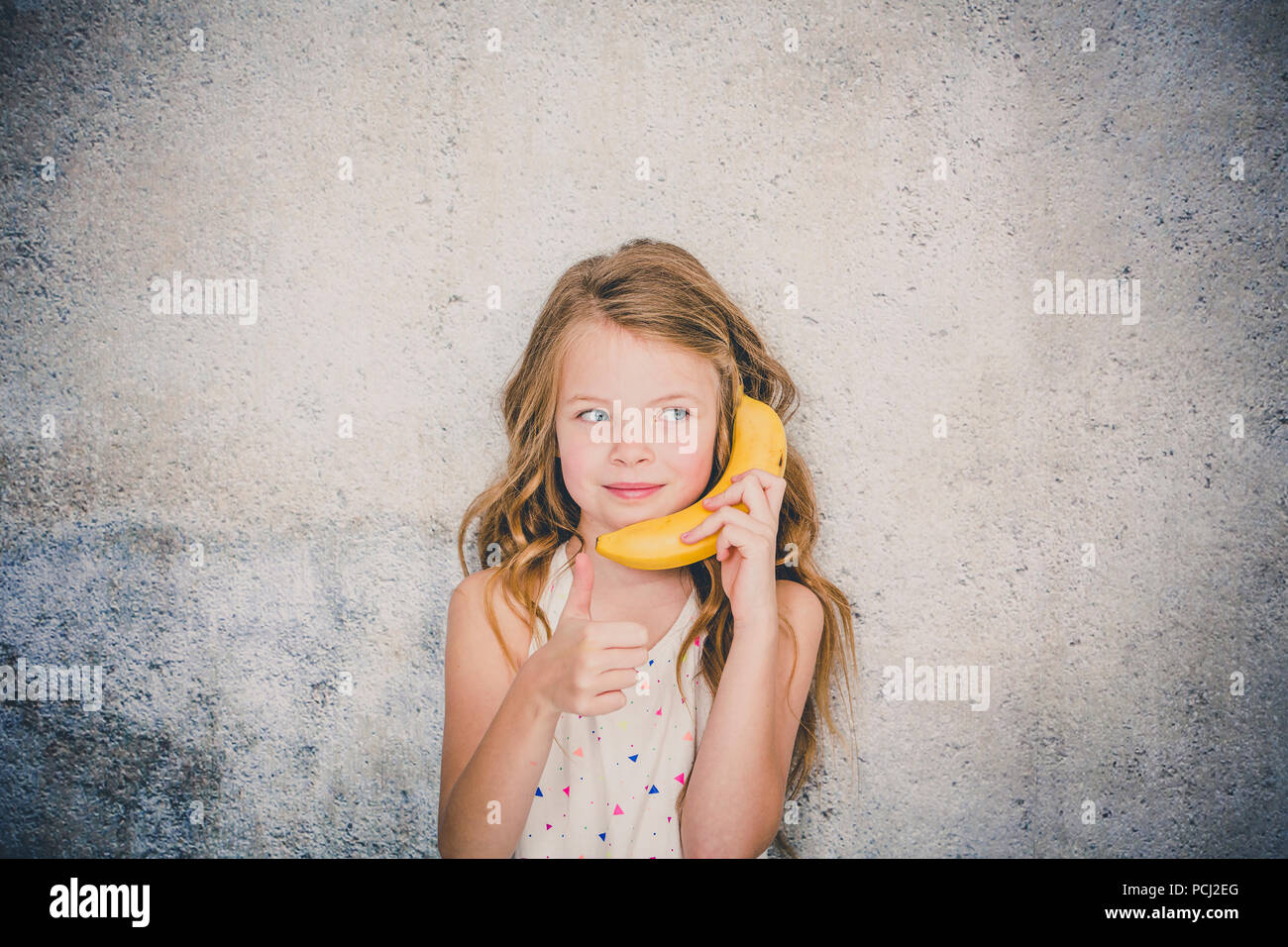 blond, Pretty girl is doing phone call with a banana Stock Photo - Alamy