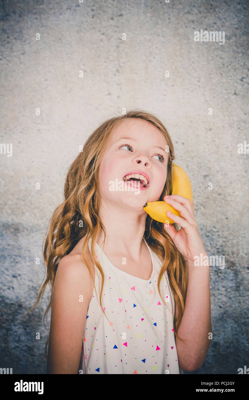 blond, Pretty girl is doing phone call with a banana Stock Photo - Alamy