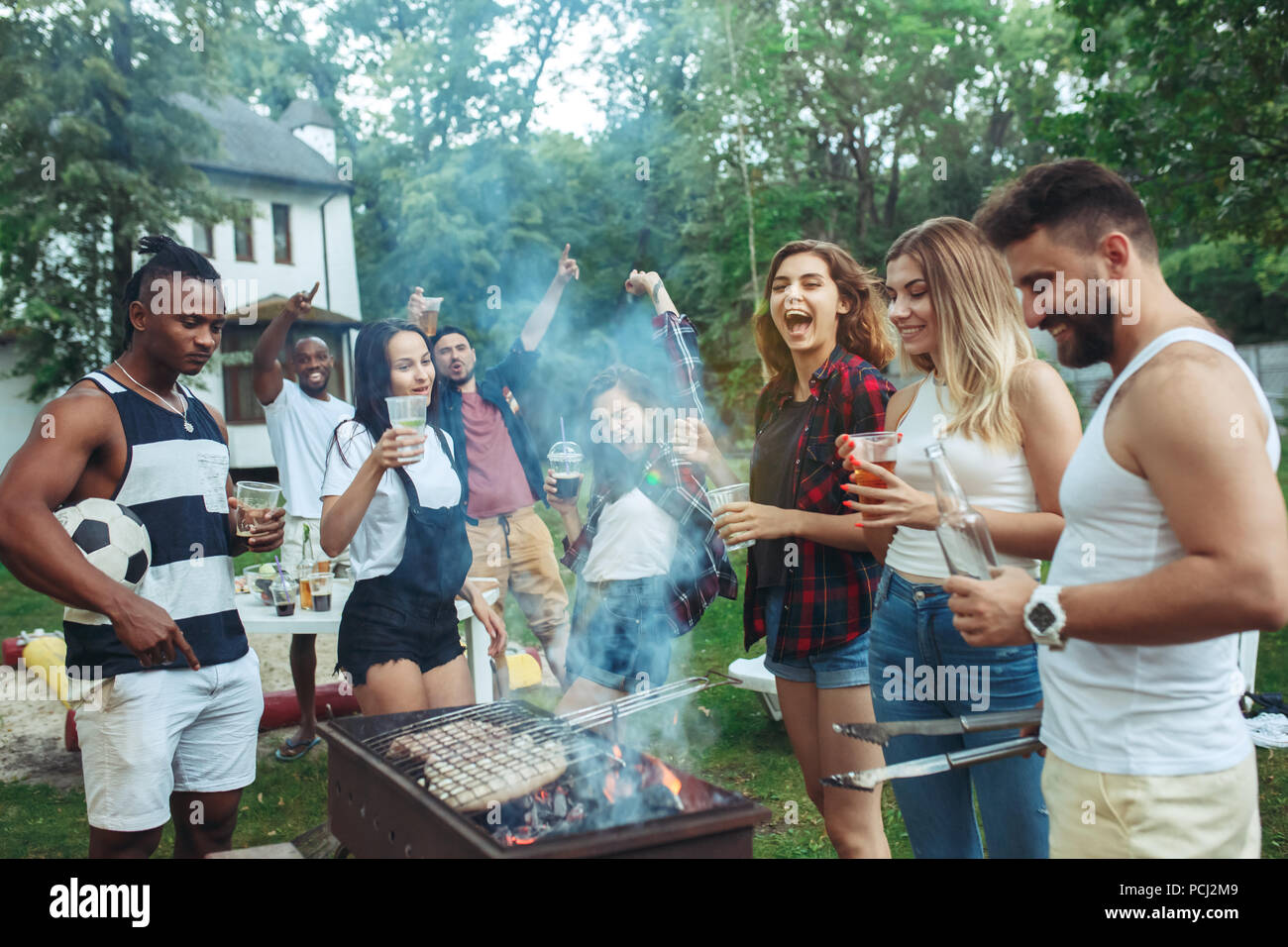 Group of friends making barbecue in the backyard. concept about good ...