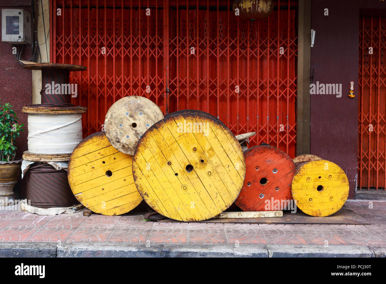 The Wooden Cable Core in front of the hardware store Stock Photo - Alamy