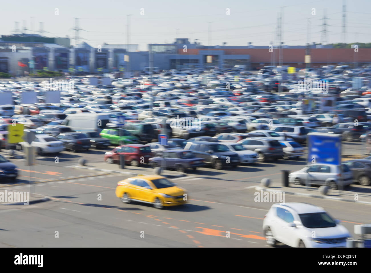 Abstract outdoor car parking next to modern mall, cars driving in the ...