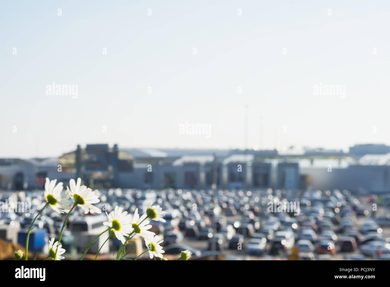 Abstract blurry car park next to modern mall, summer sunny day, with ...