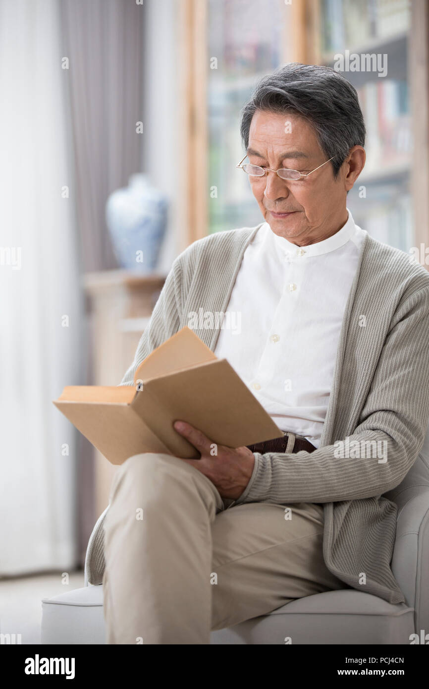 Senior Chinese man reading a book Stock Photo - Alamy