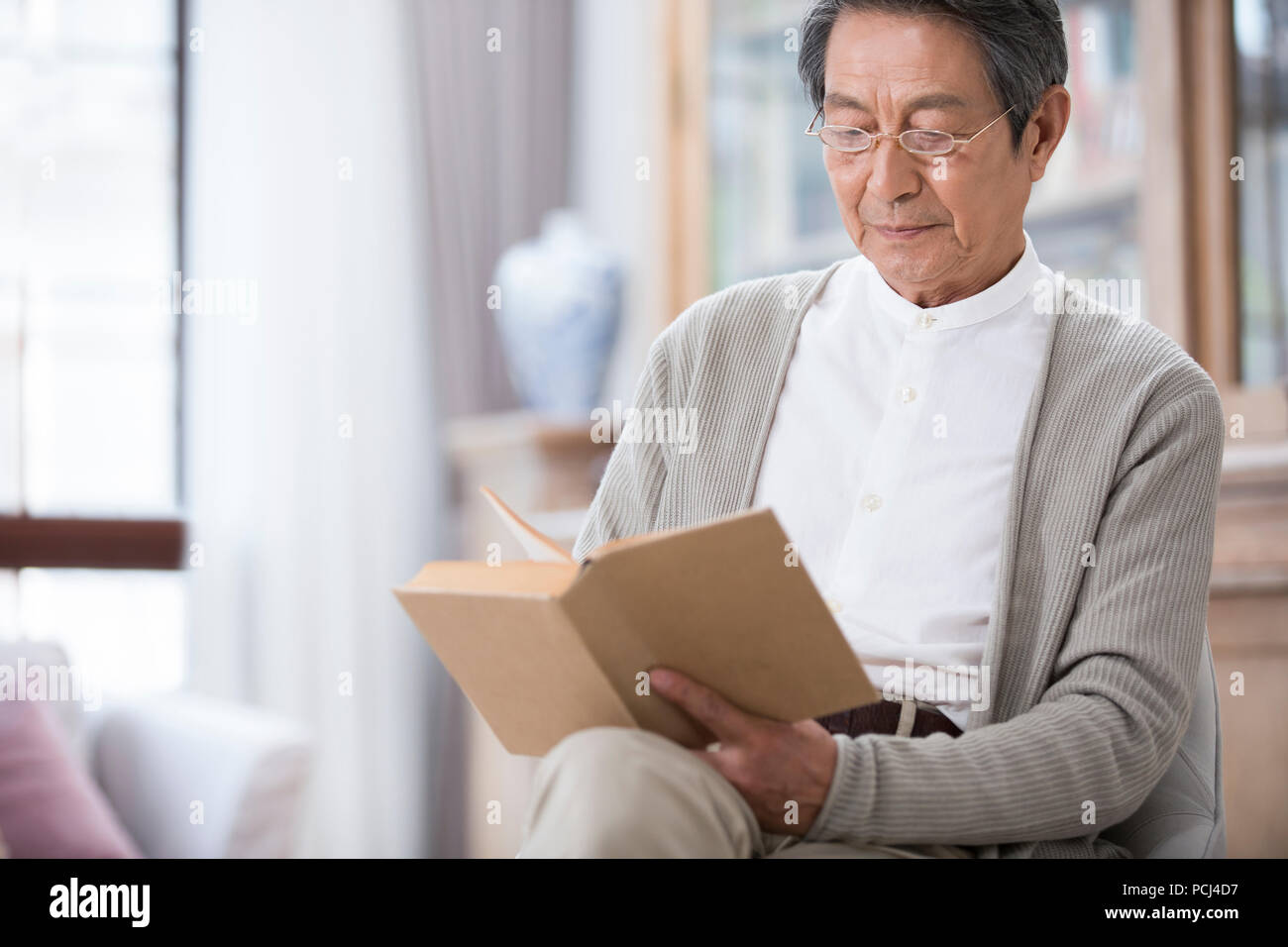 Senior Chinese man reading a book Stock Photo - Alamy