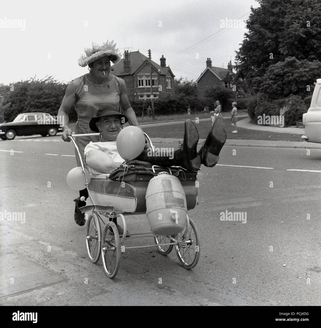1960s, historical, English village pram race, two male competitors in ...