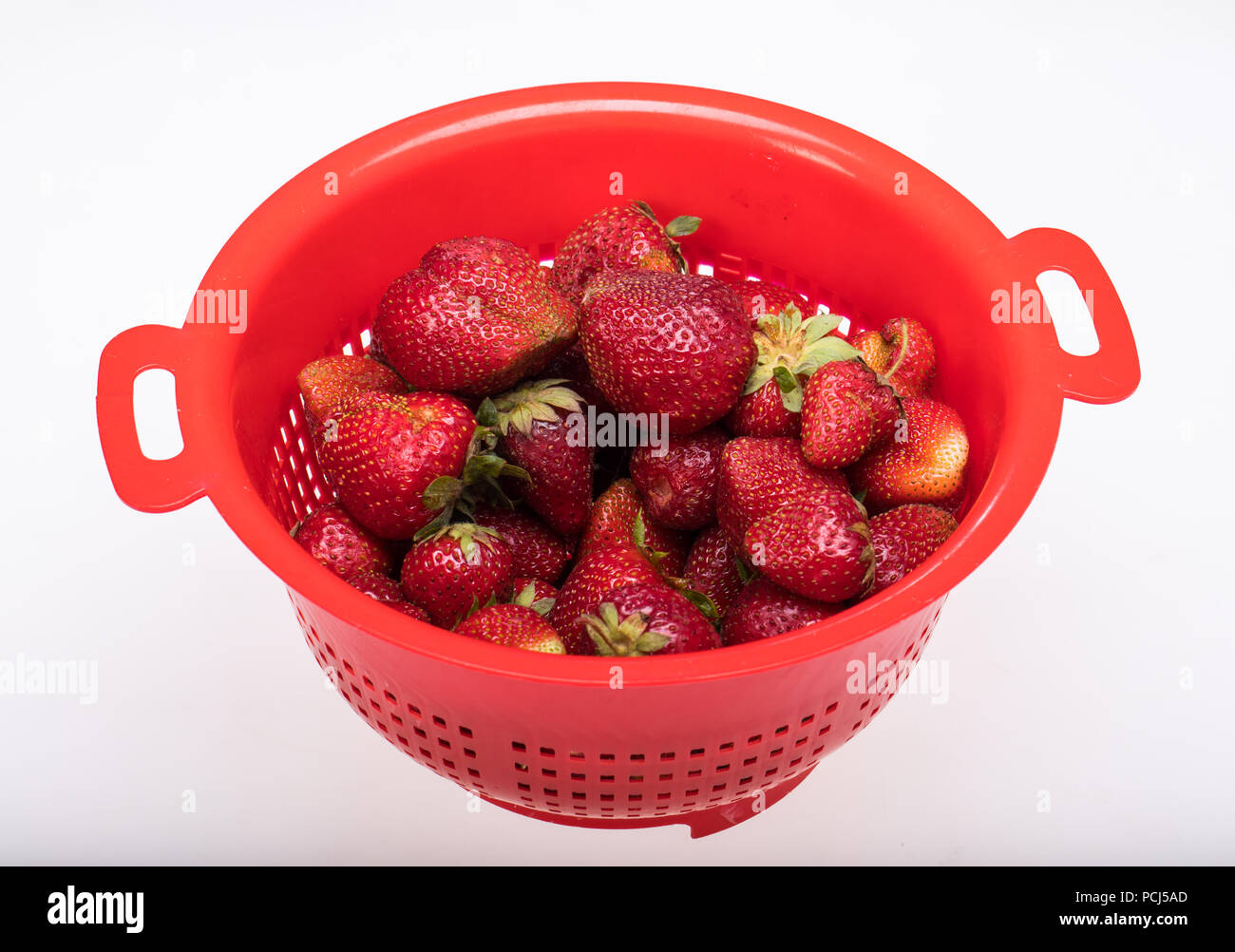 washed fresh ripe strawberries in a red plastic strainer Stock Photo ...