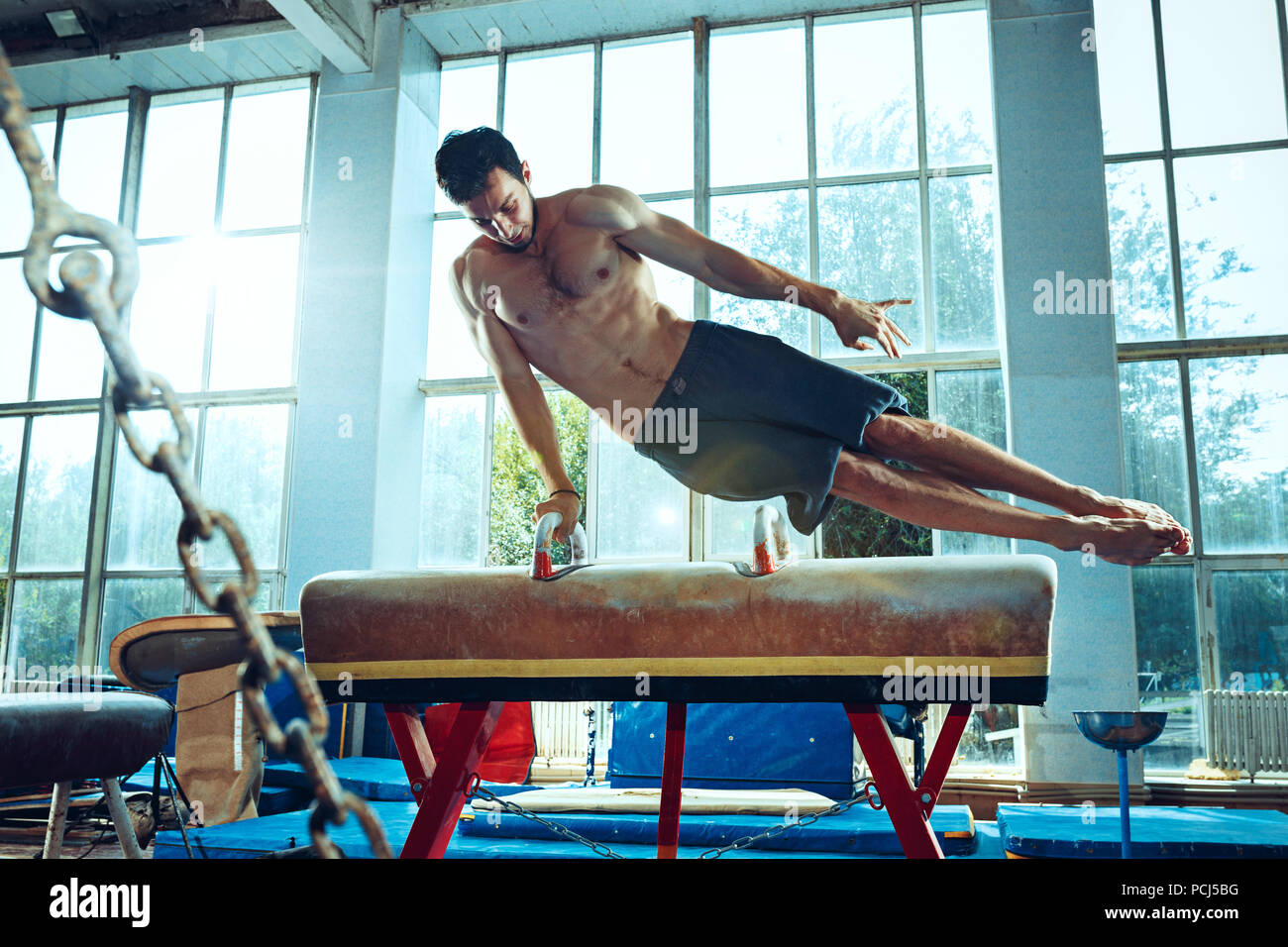 The sportsman during difficult exercise, sports gymnastics Stock Photo ...