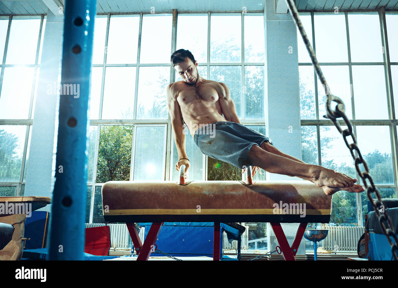 The sportsman during difficult exercise, sports gymnastics Stock Photo ...