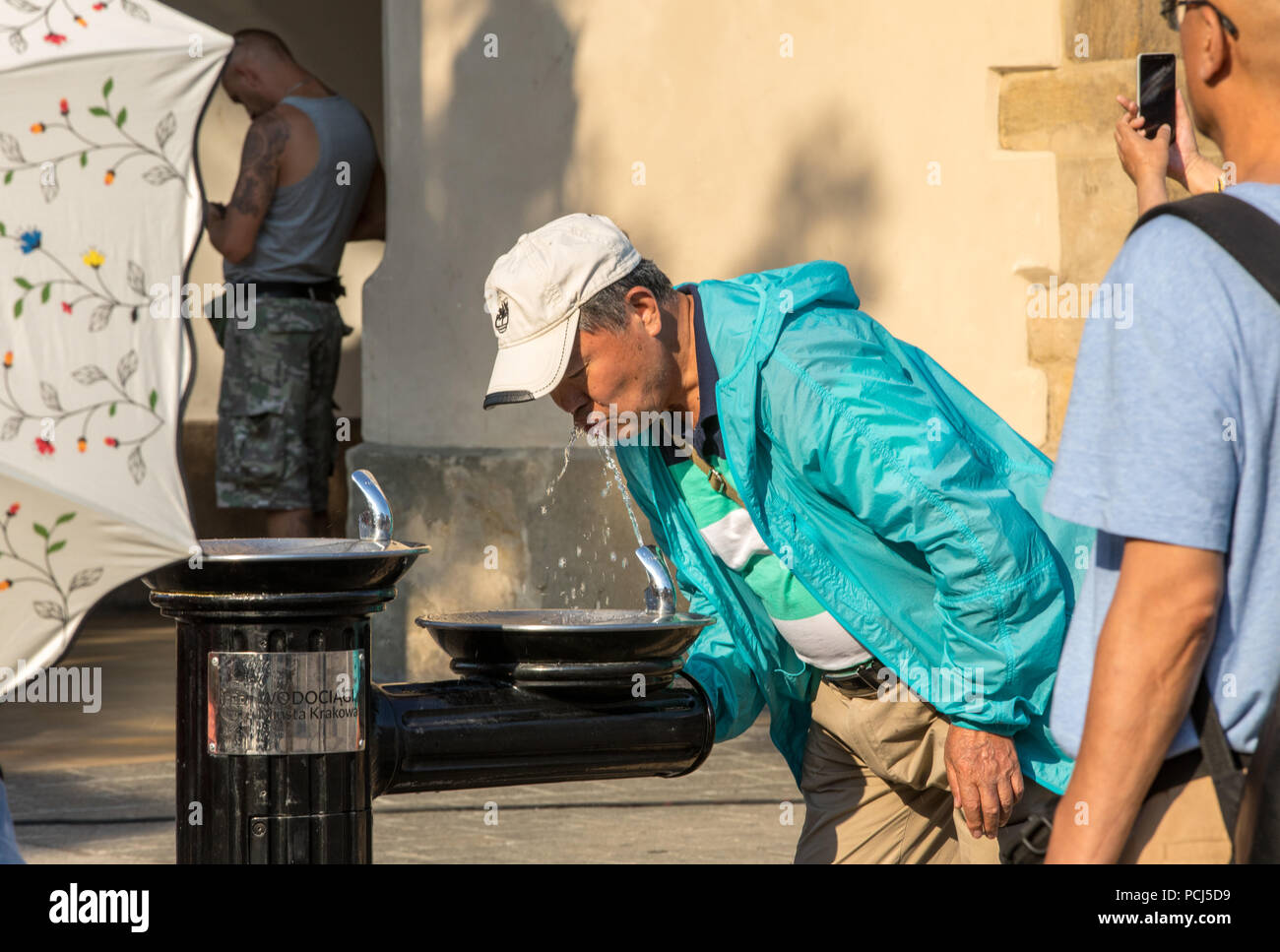Cracow, Poland - July 5, 2018: Woman is refreshing at fountain in ...
