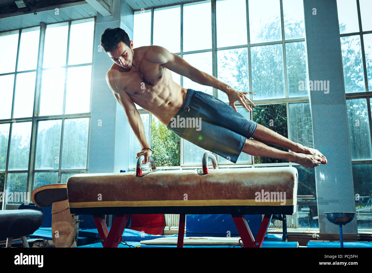 The sportsman during difficult exercise, sports gymnastics Stock Photo ...