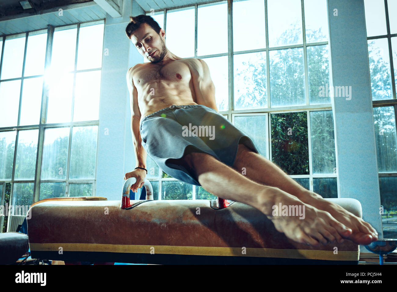 The sportsman during difficult exercise, sports gymnastics Stock Photo ...