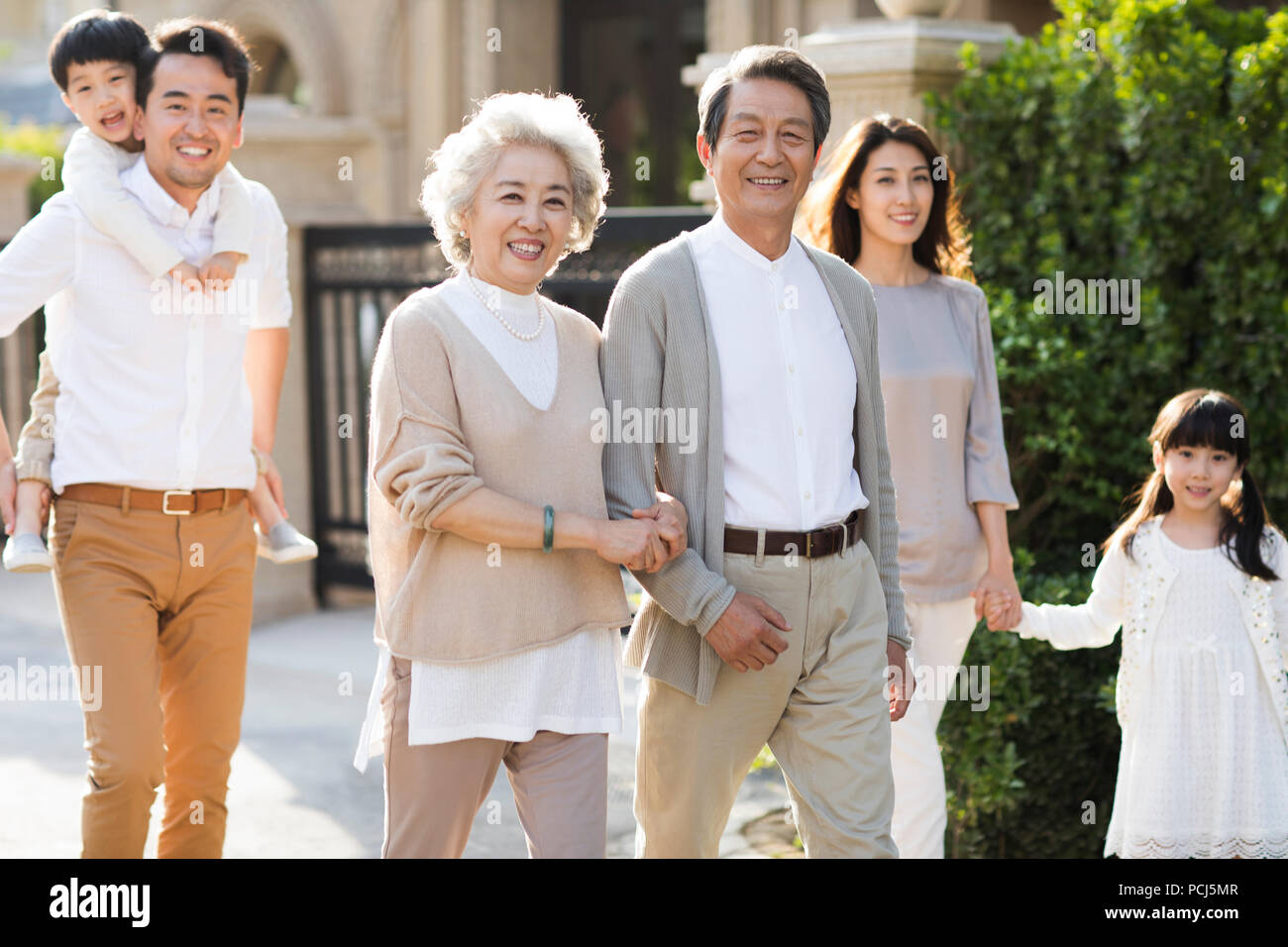Happy Chinese family strolling outside Stock Photo - Alamy