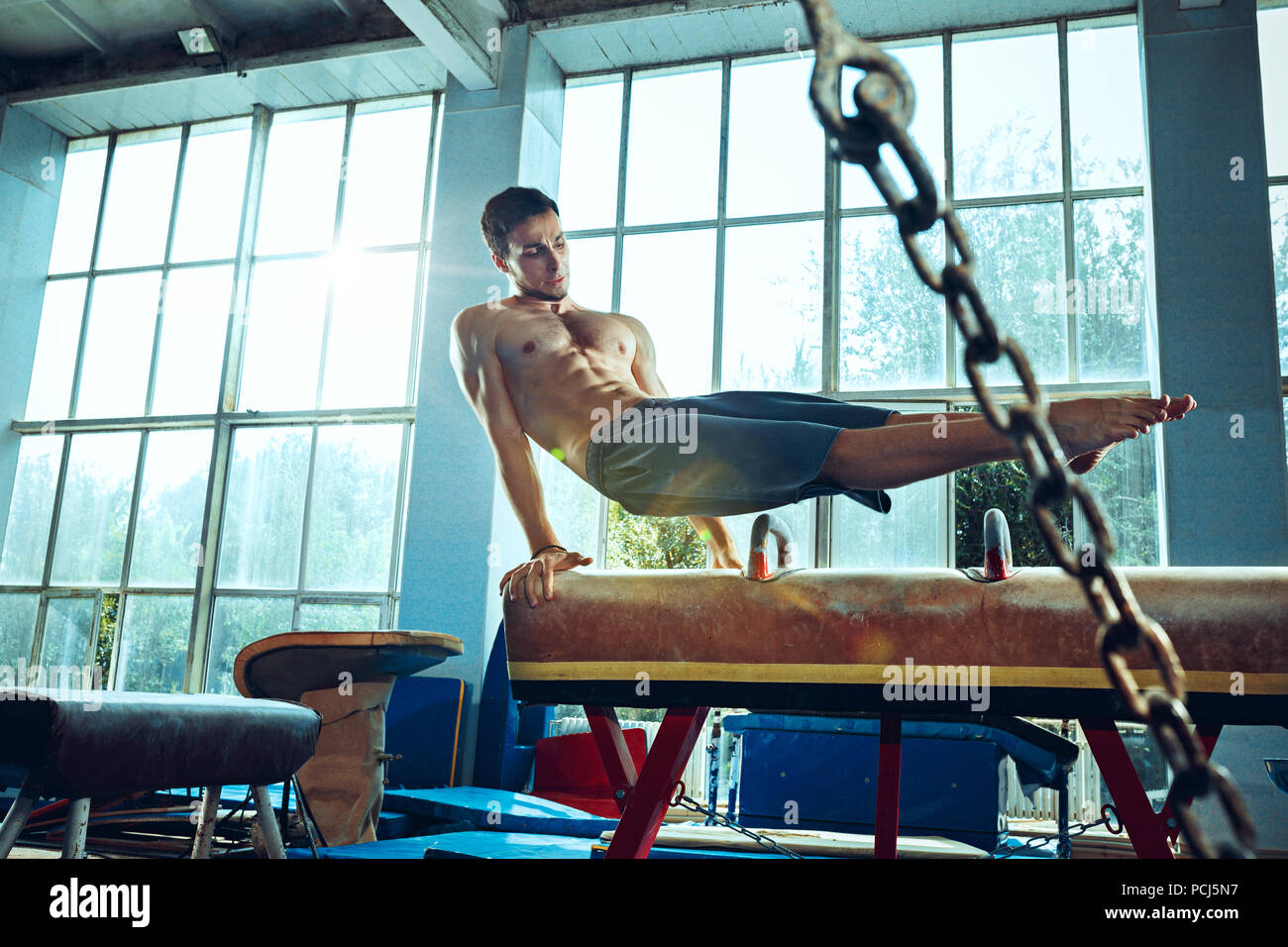 The sportsman during difficult exercise, sports gymnastics Stock Photo ...