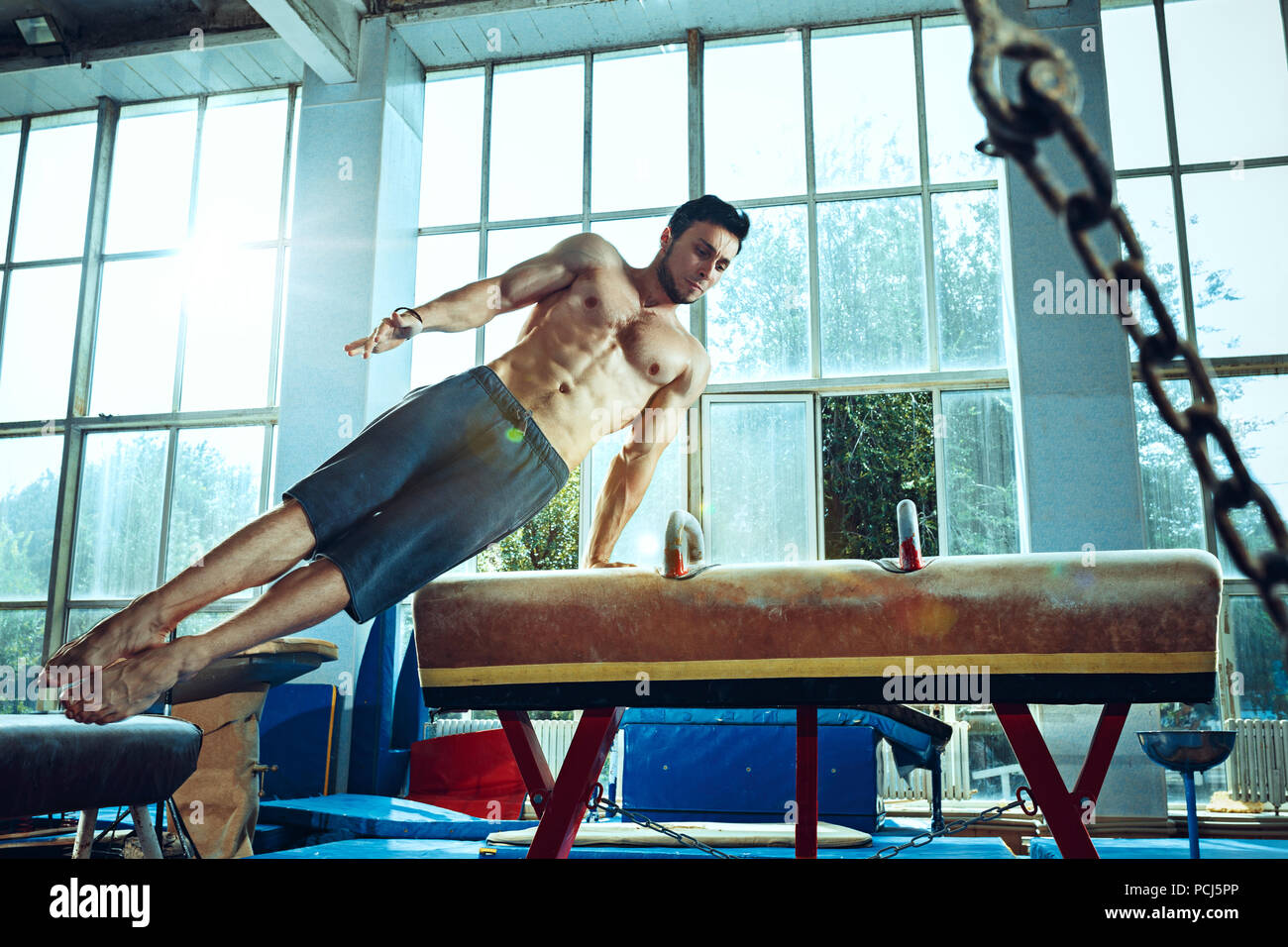 The sportsman during difficult exercise, sports gymnastics Stock Photo ...