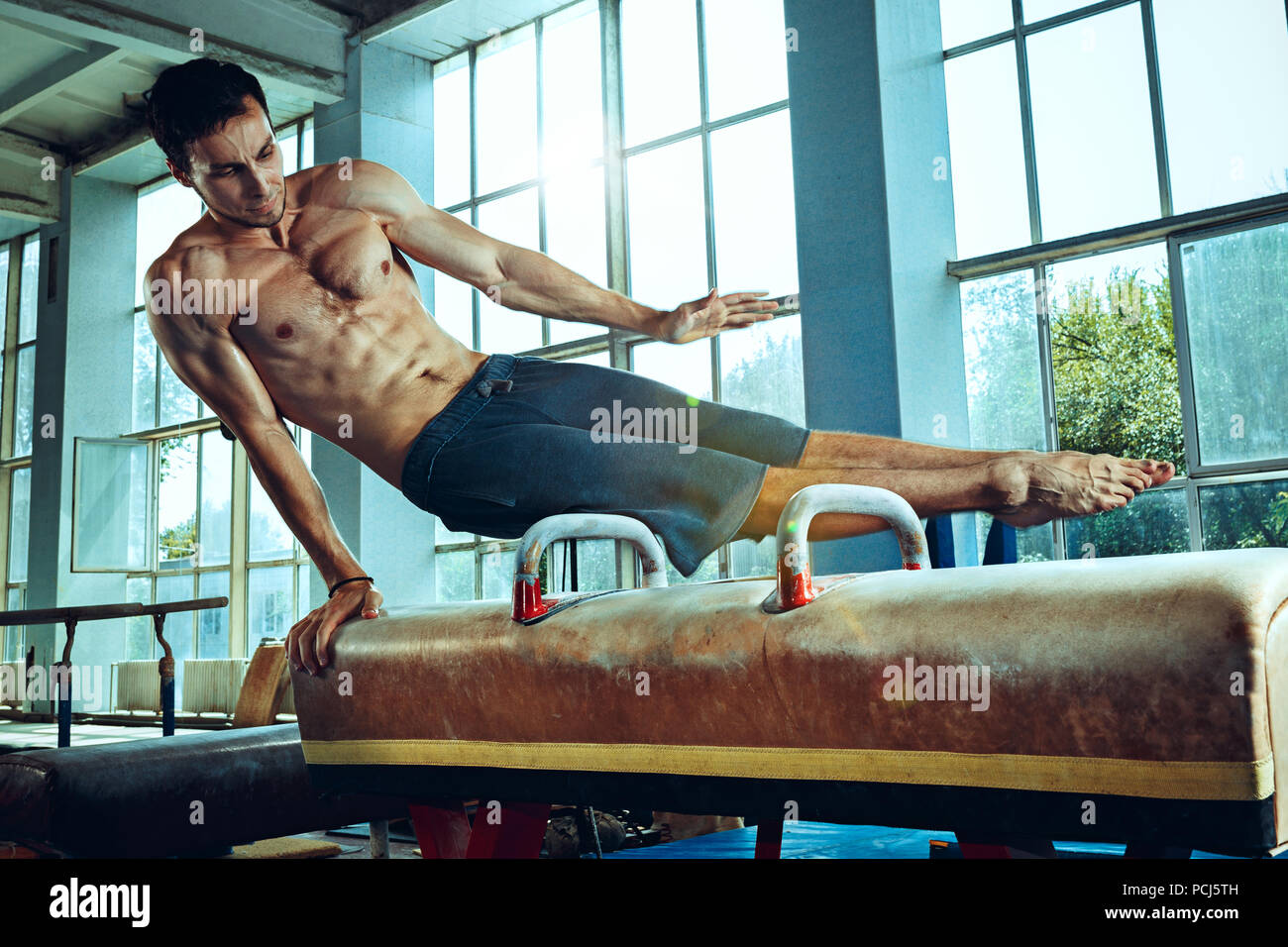 The sportsman during difficult exercise, sports gymnastics Stock Photo ...