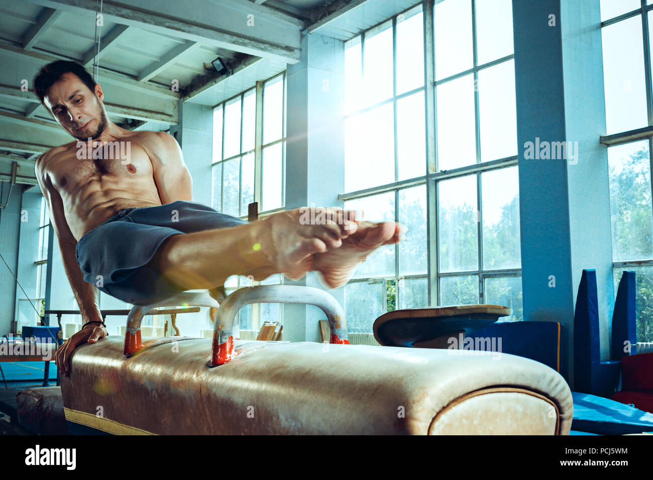 The sportsman during difficult exercise, sports gymnastics Stock Photo ...