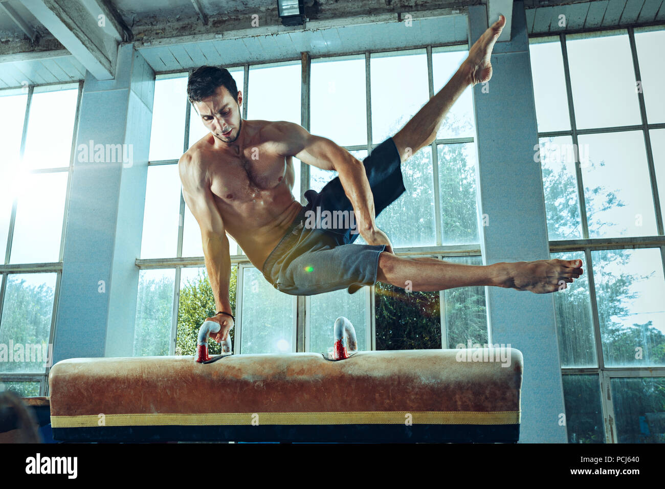 The sportsman during difficult exercise, sports gymnastics Stock Photo ...