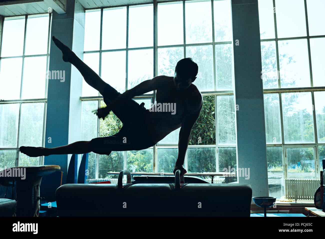 The sportsman during difficult exercise, sports gymnastics Stock Photo ...