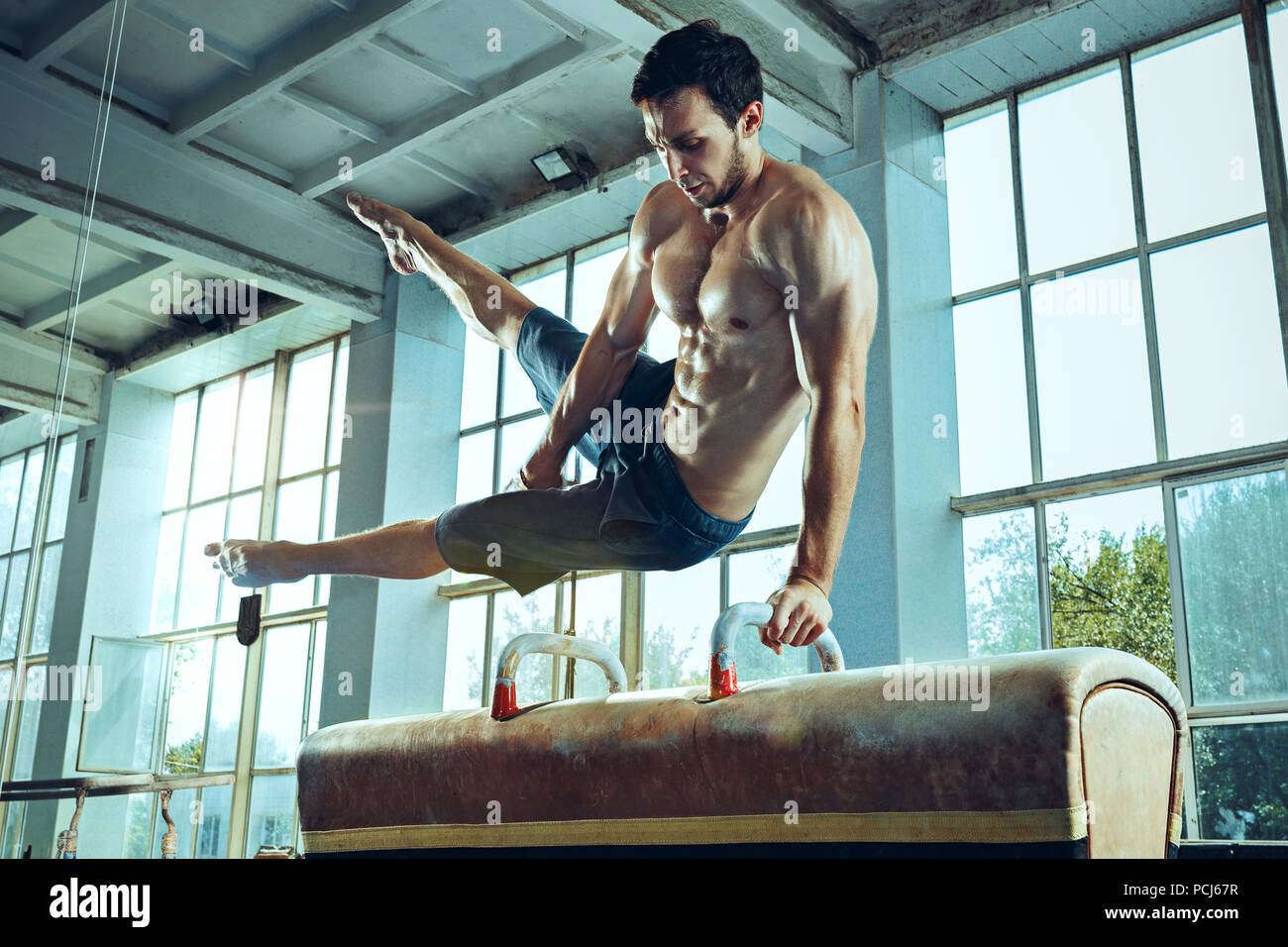 The sportsman during difficult exercise, sports gymnastics Stock Photo ...