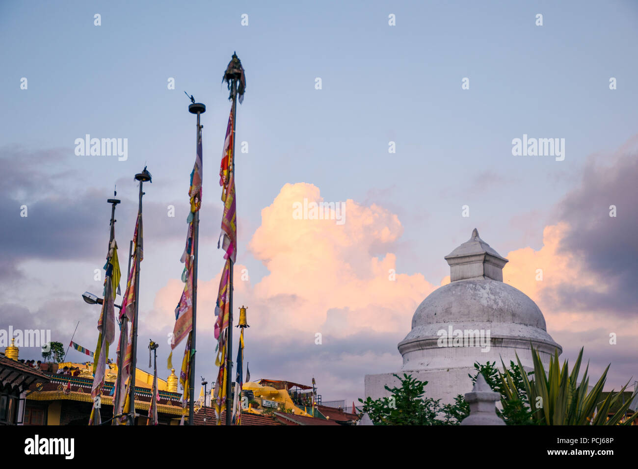 Prayer flag poles and Nepali flags next to the Buddhanath stupa shrine ...