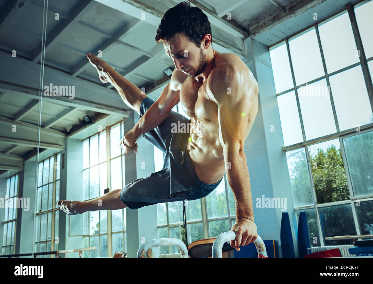 The sportsman during difficult exercise, sports gymnastics Stock Photo ...