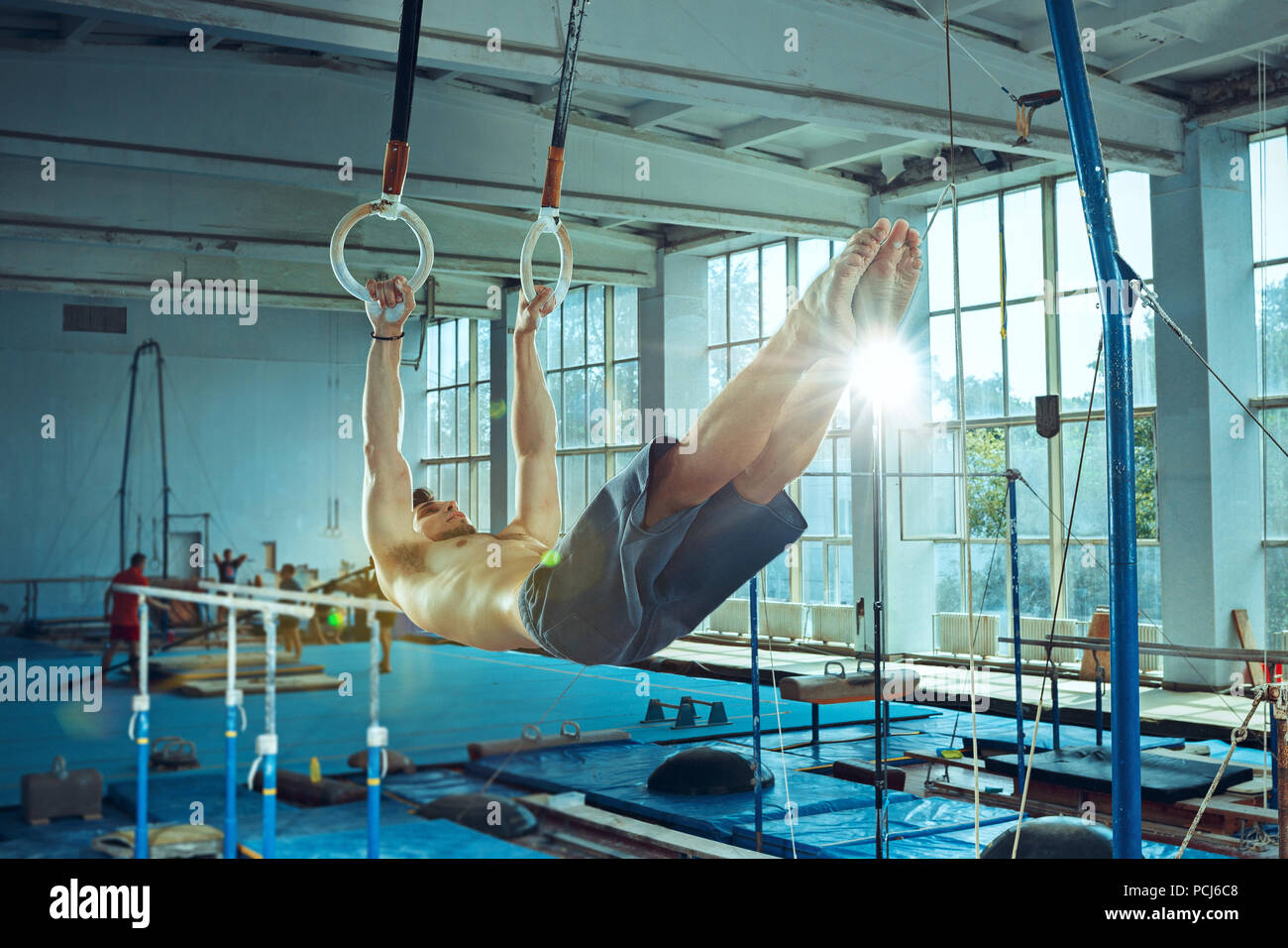 The sportsman during difficult exercise, sports gymnastics Stock Photo ...