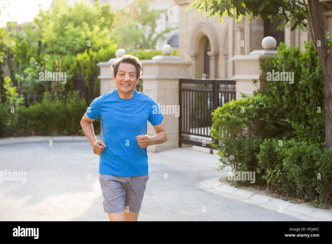 Cheerful senior Chinese man jogging outside Stock Photo - Alamy