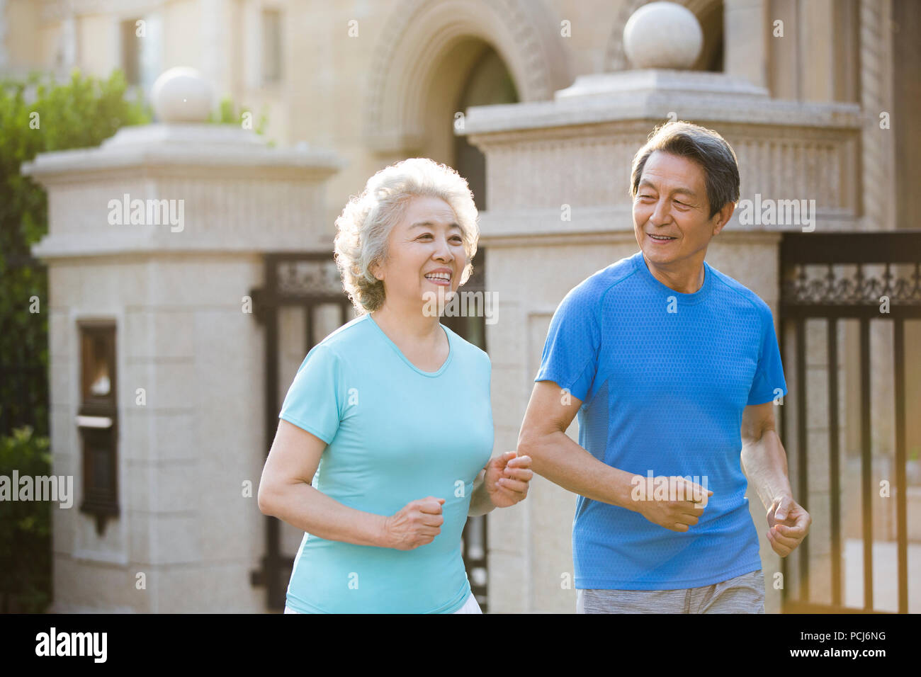 Cheerful senior Chinese couple jogging outside Stock Photo - Alamy