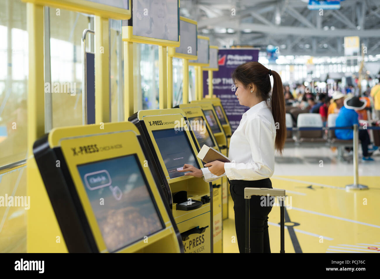 Young Asian businesswoman using self check-in kiosks in airport ...