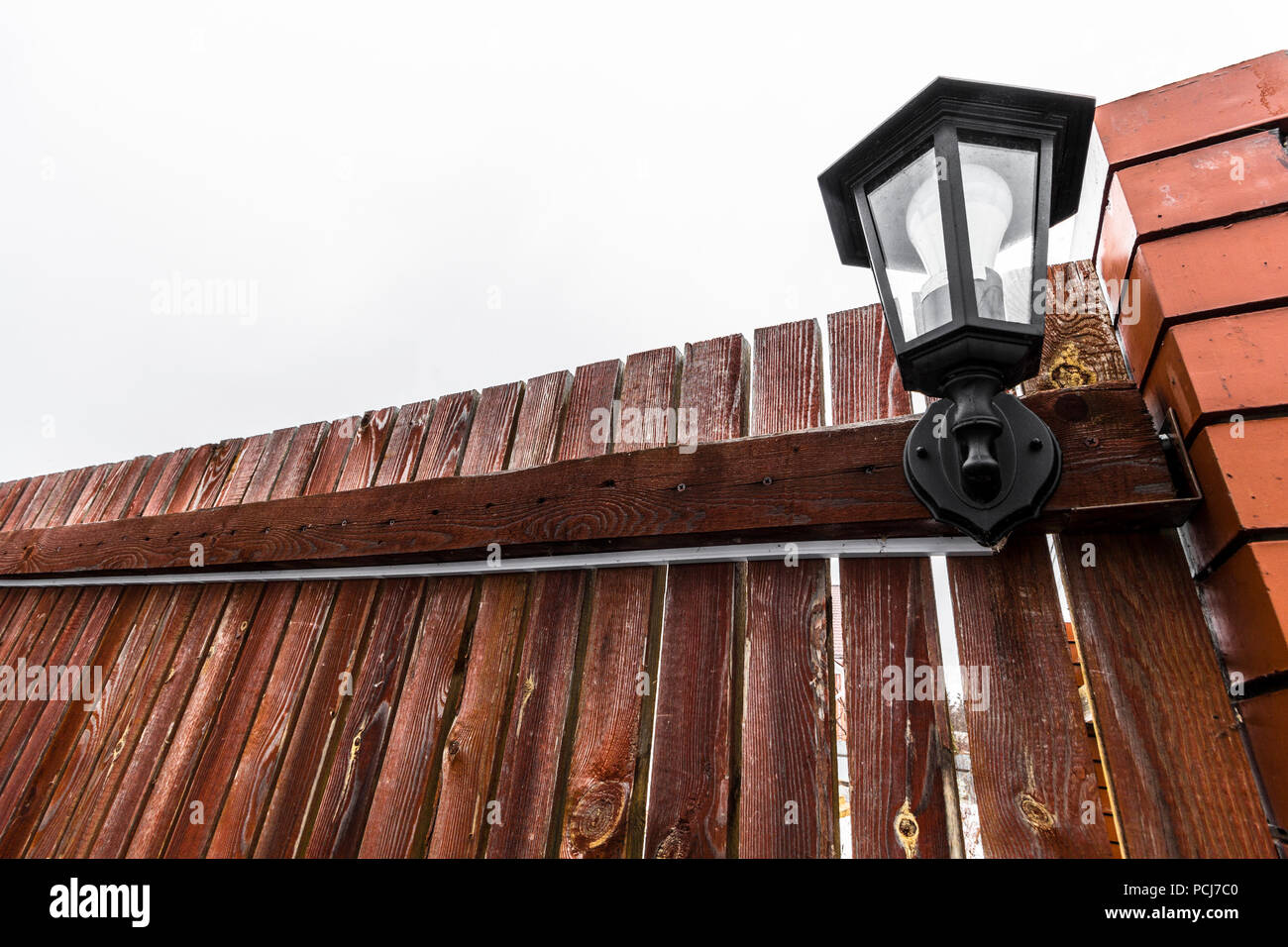 A street lamp hangs on a fence in the backyard of a private house Stock ...