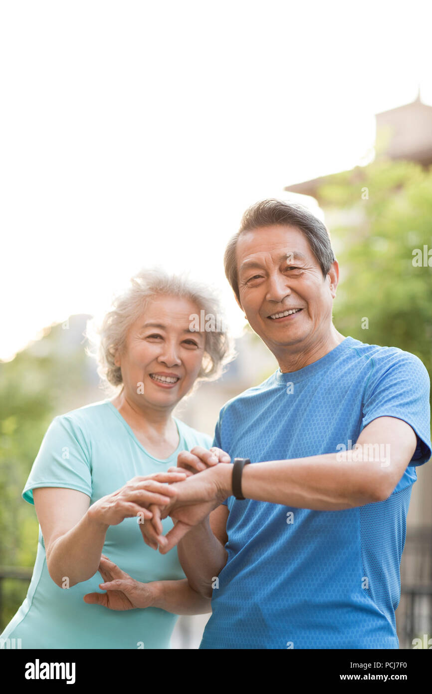Cheerful senior Chinese couple checking smart watch Stock Photo - Alamy