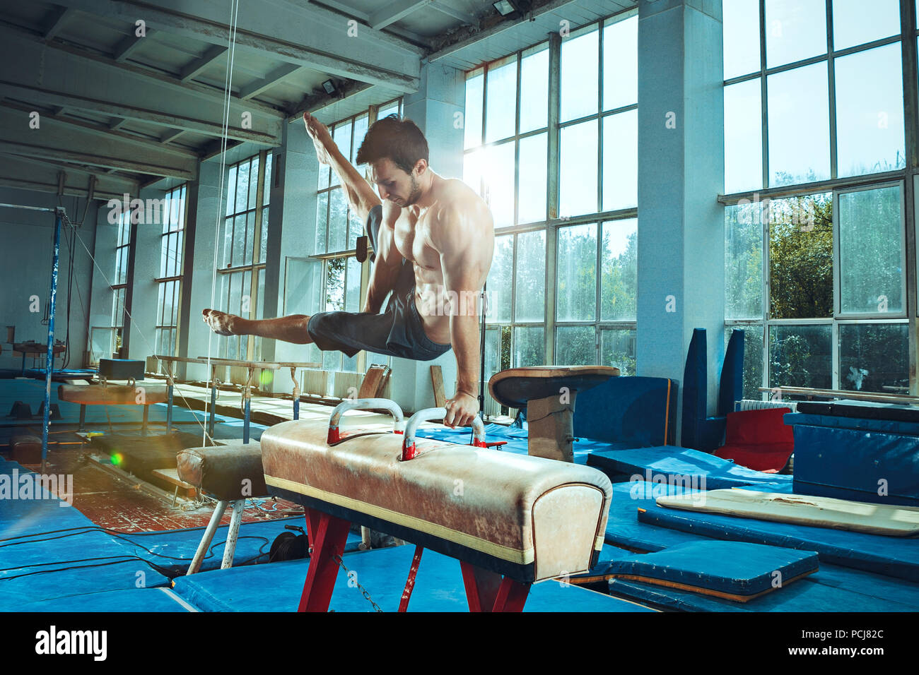 The sportsman during difficult exercise, sports gymnastics Stock Photo ...