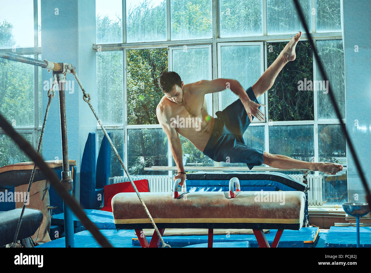 The sportsman during difficult exercise, sports gymnastics Stock Photo ...