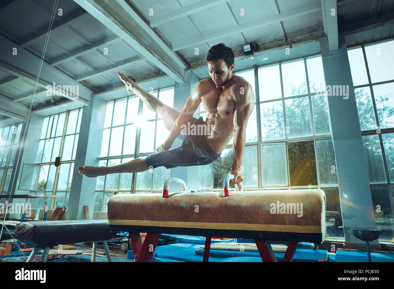 The sportsman during difficult exercise, sports gymnastics Stock Photo ...