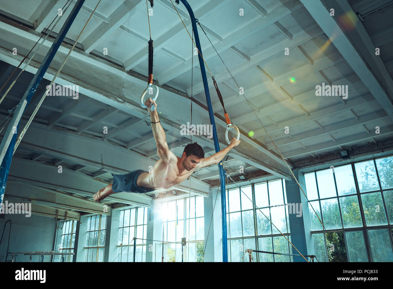The sportsman during difficult exercise, sports gymnastics Stock Photo ...