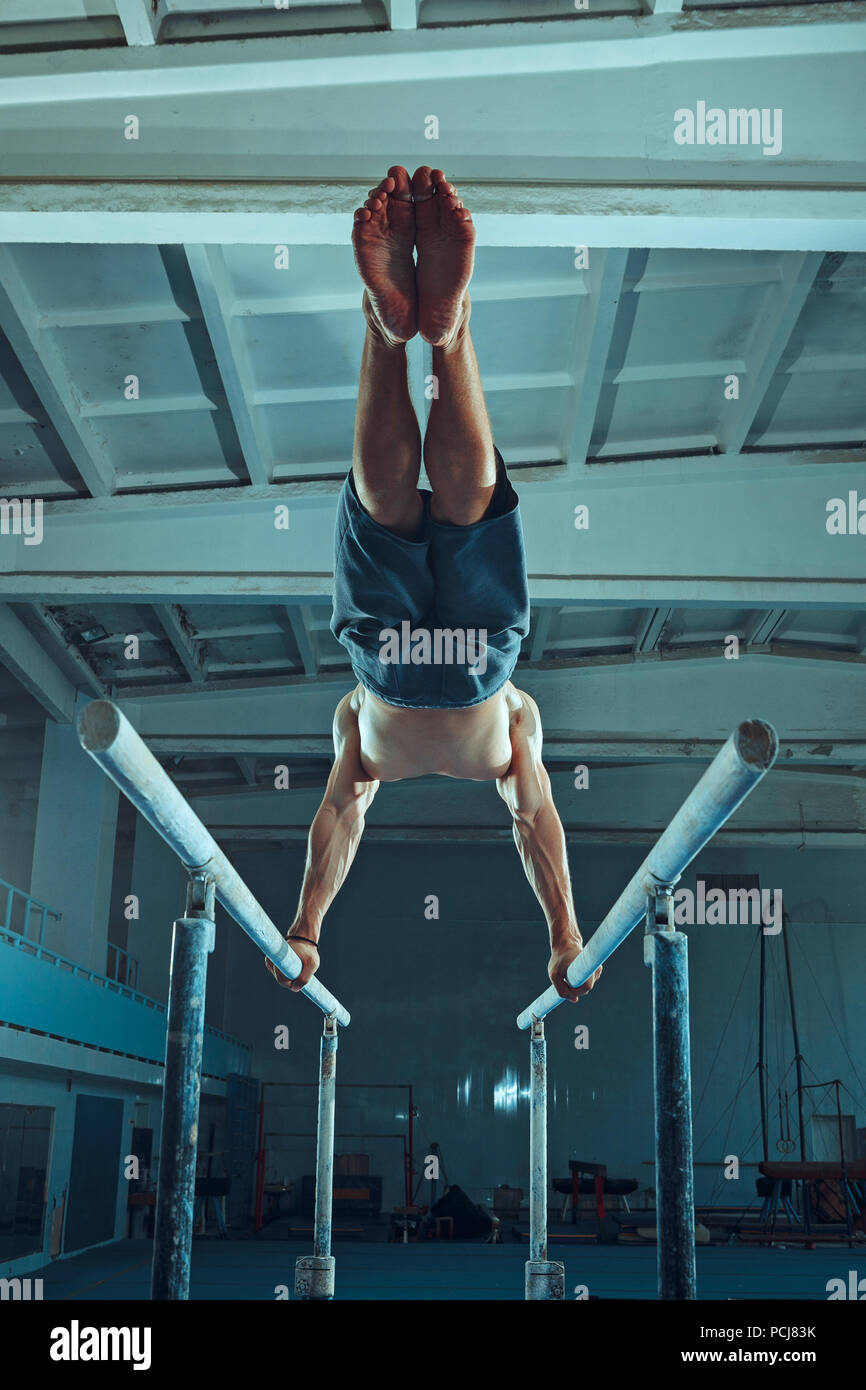 The sportsman during difficult exercise, sports gymnastics Stock Photo ...