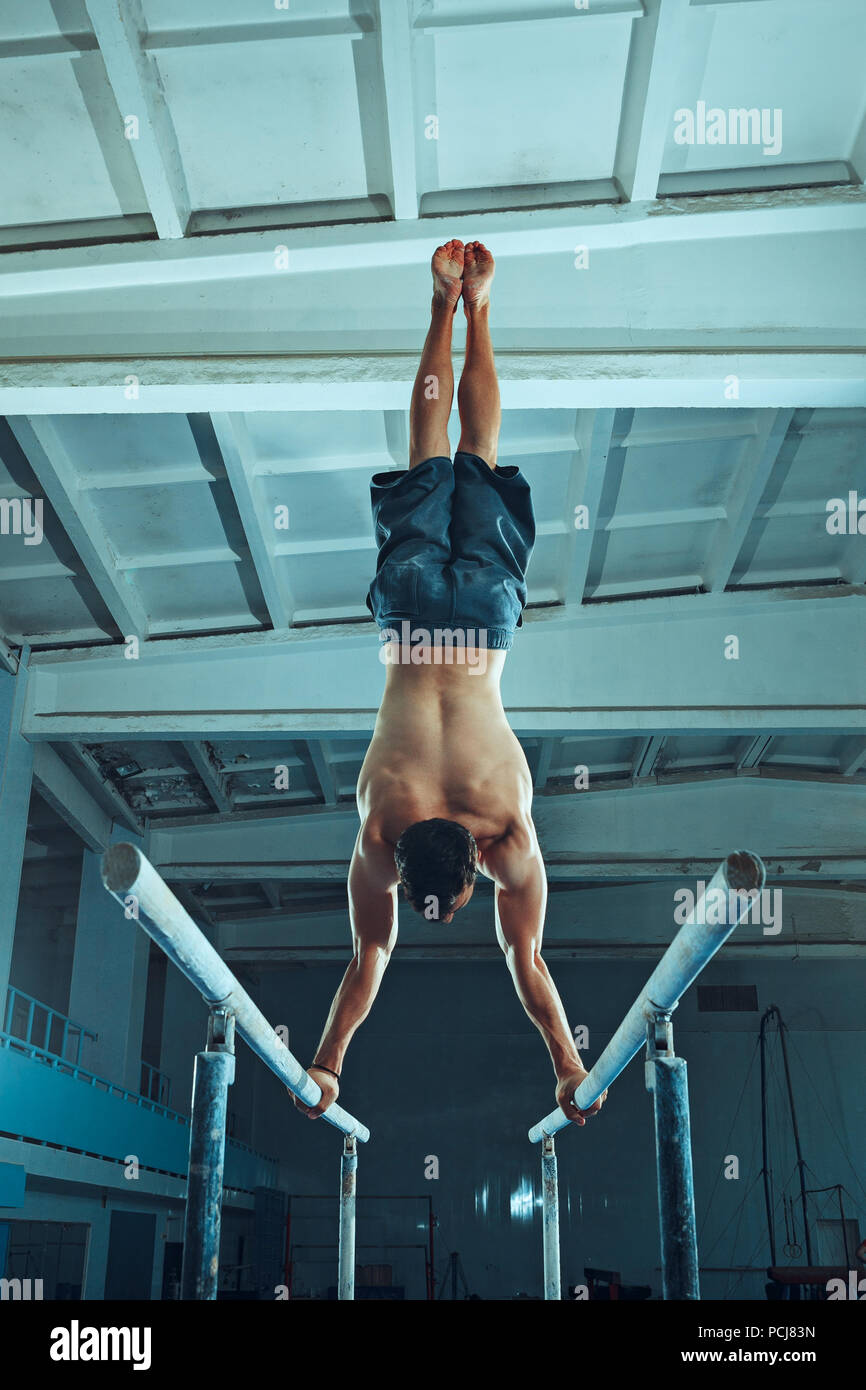 The sportsman during difficult exercise, sports gymnastics Stock Photo ...