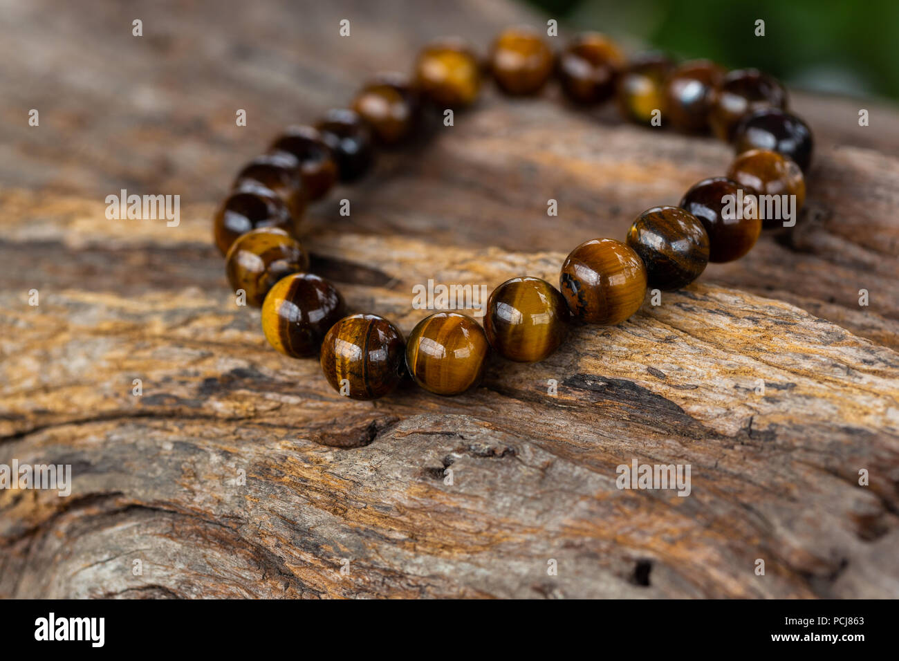 Tiger Eyes Stone Bracelet on the stump wood Stock Photo - Alamy