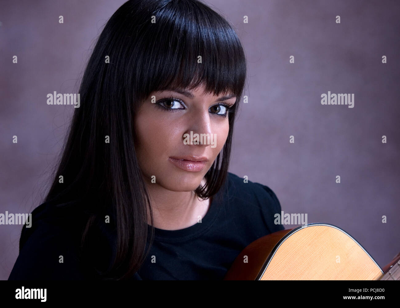 Portrait of beautiful young brunette playing guitar Stock Photo - Alamy