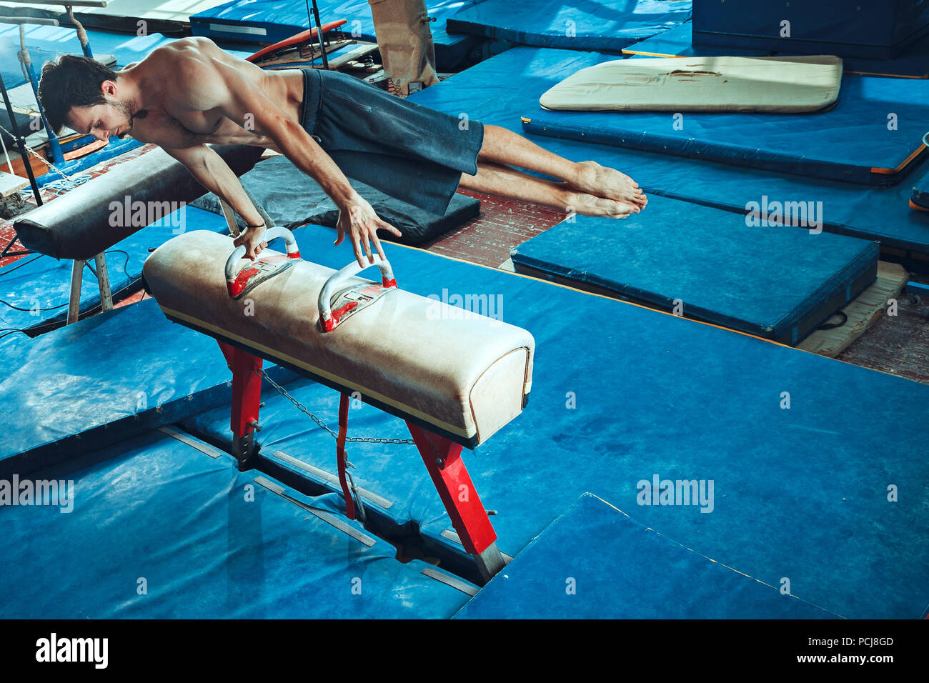 The sportsman during difficult exercise, sports gymnastics Stock Photo ...