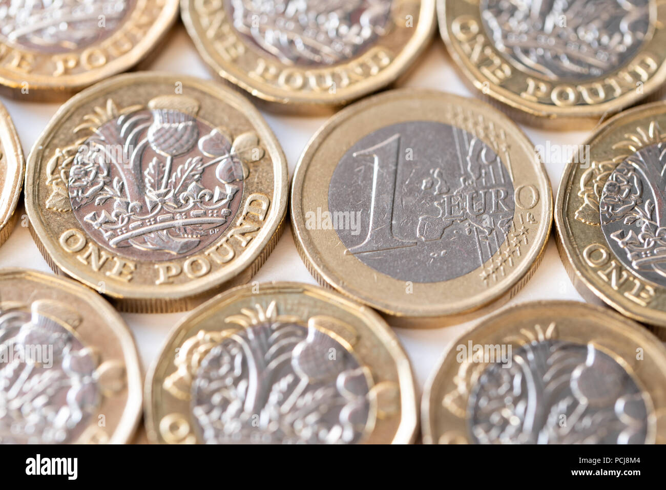 Stack of Euro coins and new pound coins isolated on white background ...