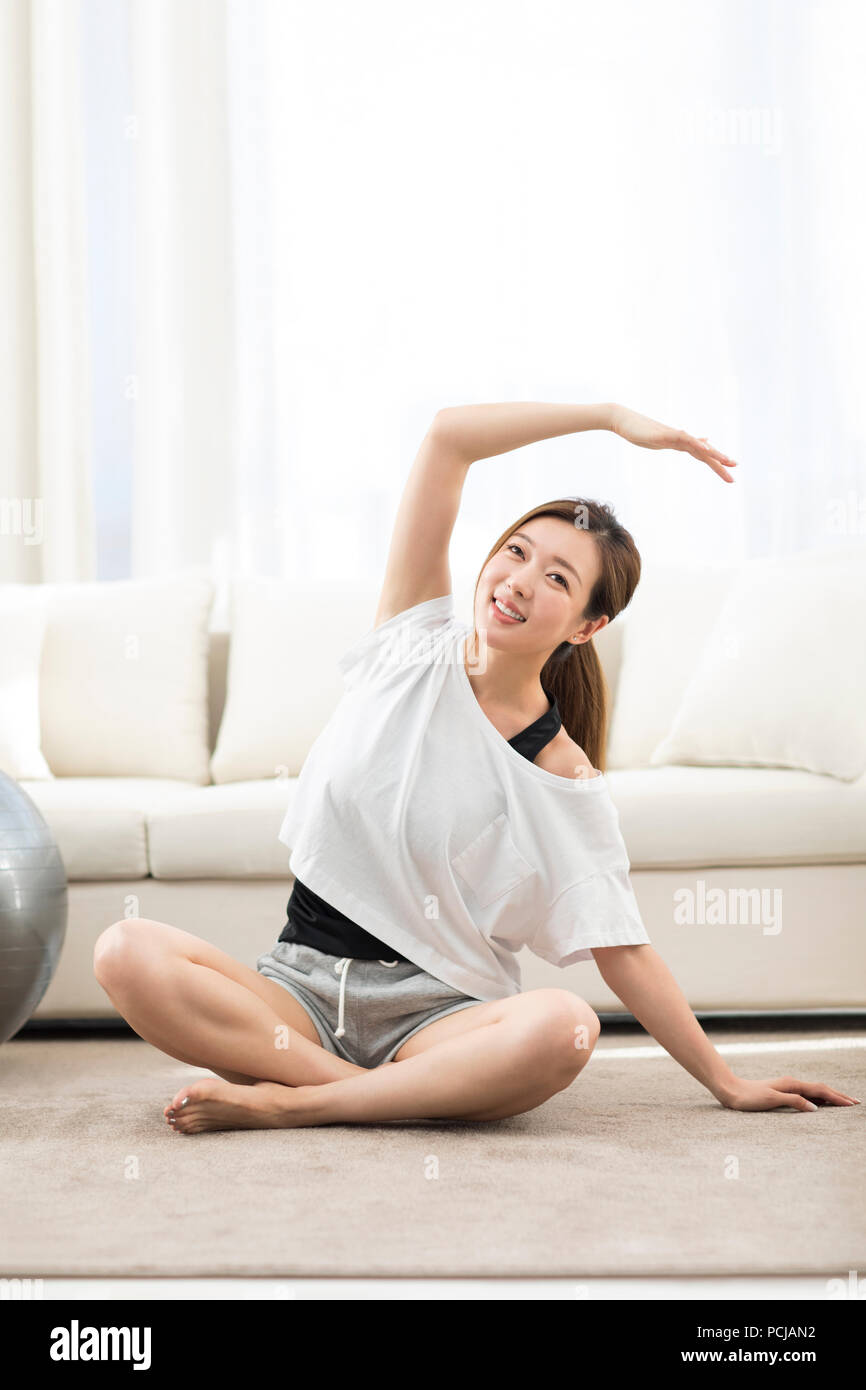 Young Chinese woman practicing yoga at home Stock Photo - Alamy